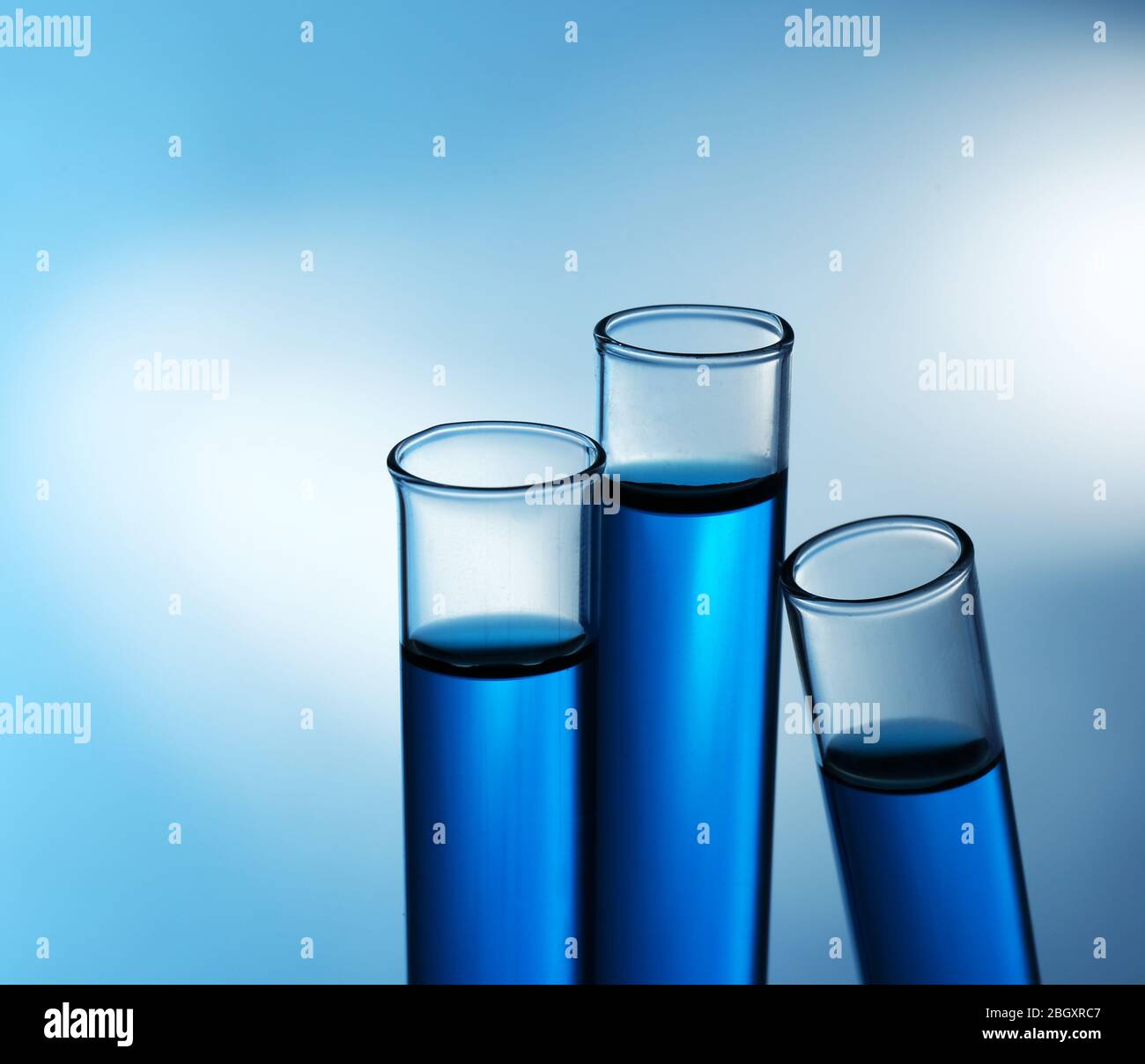 Inclined test-tubes with blue water on the shadows background Stock ...