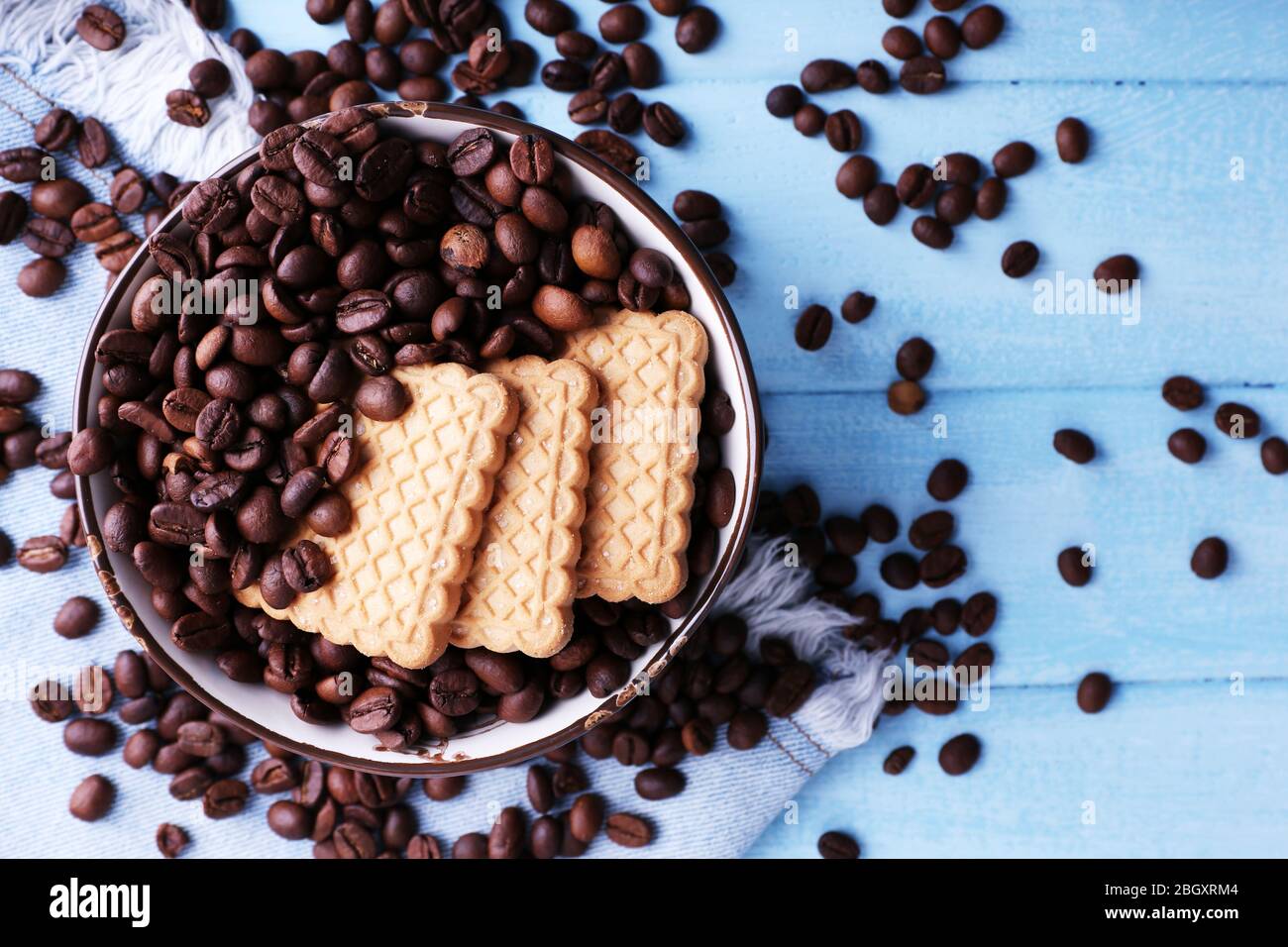Bowl of shortbread cookies and coffee beans on blue wooden background ...