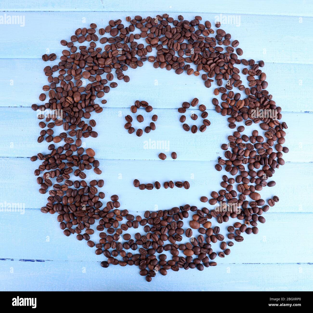 Face of coffee beans on blue wooden background Stock Photo - Alamy