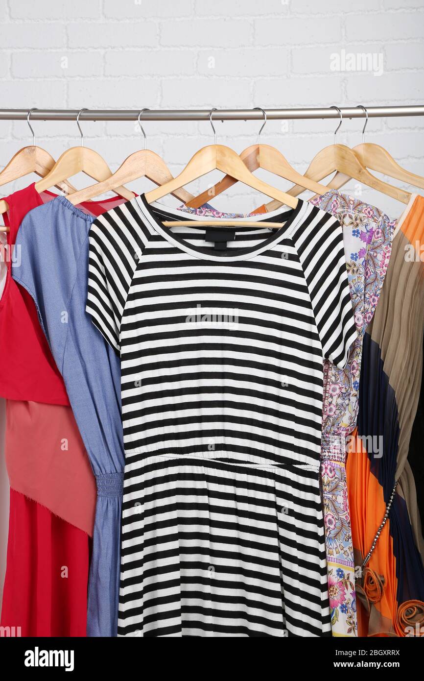 Female dresses on hangers in room Stock Photo - Alamy