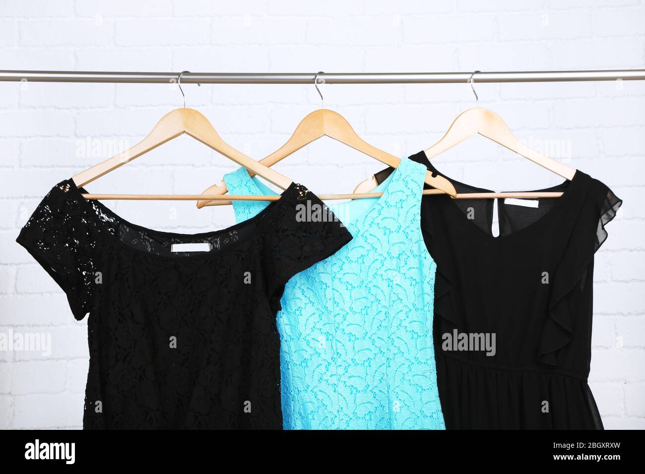 Female dresses on hangers in room Stock Photo - Alamy