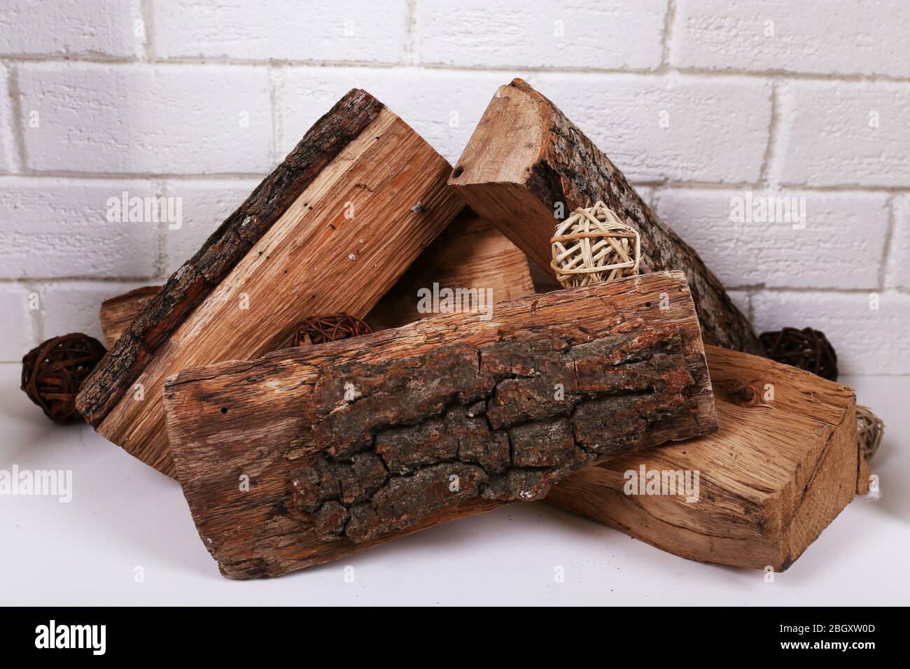 Logs in fireplace on brick wall background Stock Photo - Alamy
