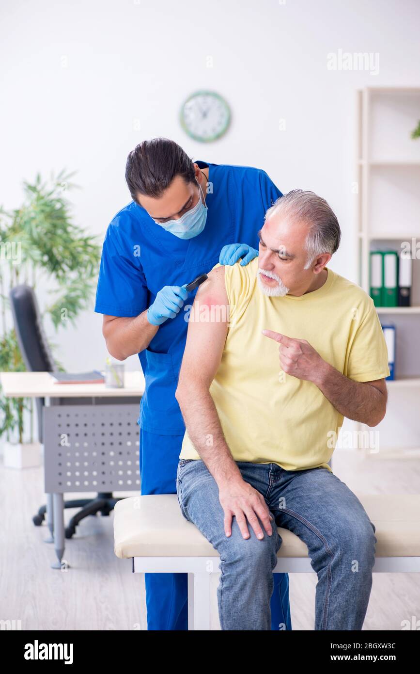Injured old man visiting male doctor traumatologist Stock Photo - Alamy