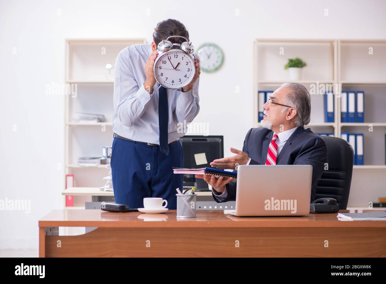 Old boss and young employee in the office Stock Photo - Alamy