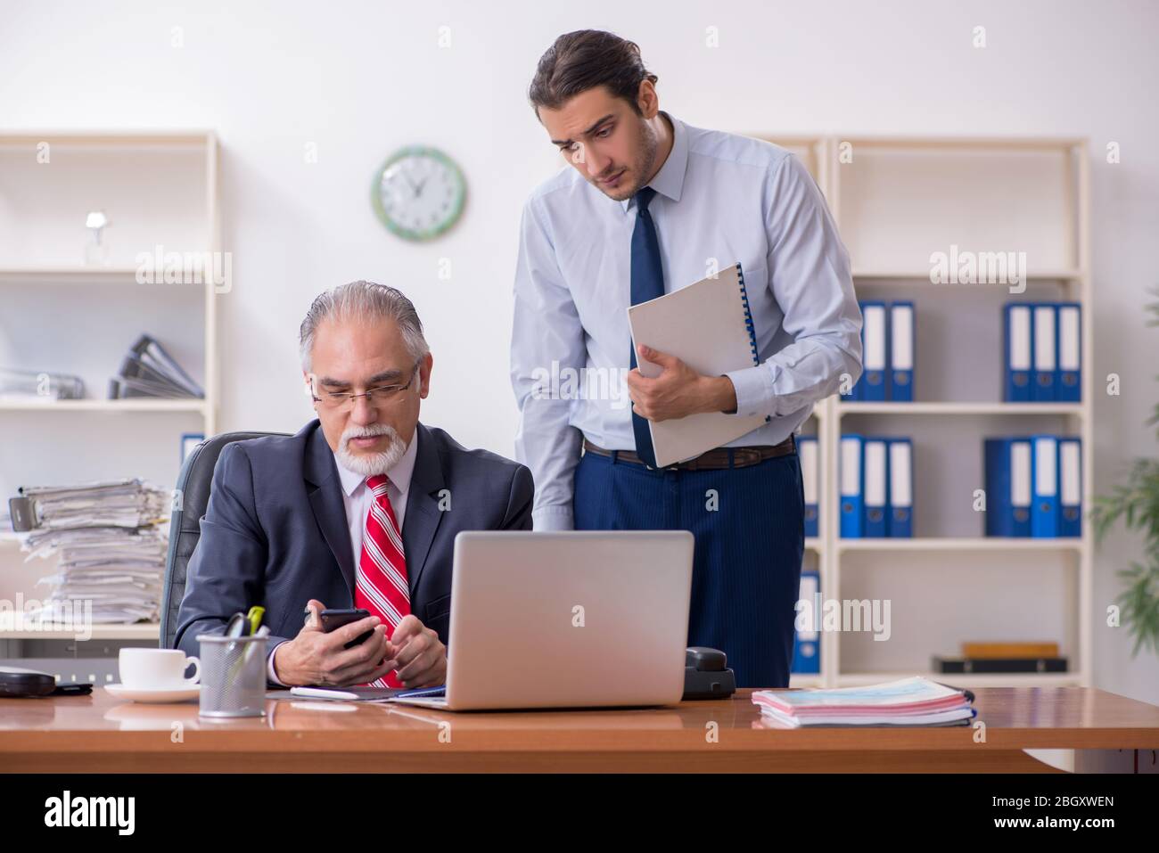 Old boss and young employee in the office Stock Photo - Alamy