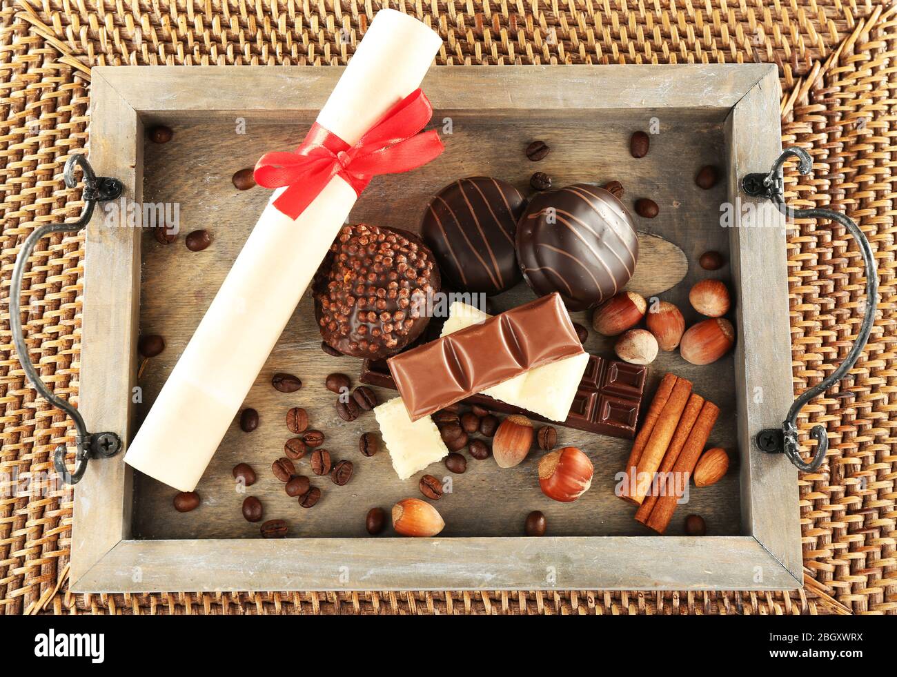 Sweets with rolled paper on wooden stand and wicker mat background ...