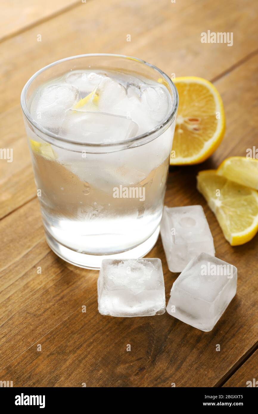 Glass of water with ice cubes on wooden table Stock Photo - Alamy