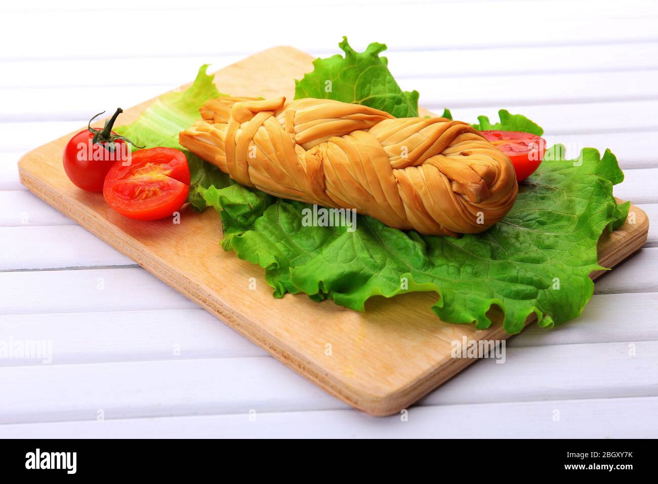 Smoked braided cheese on wooden table Stock Photo - Alamy