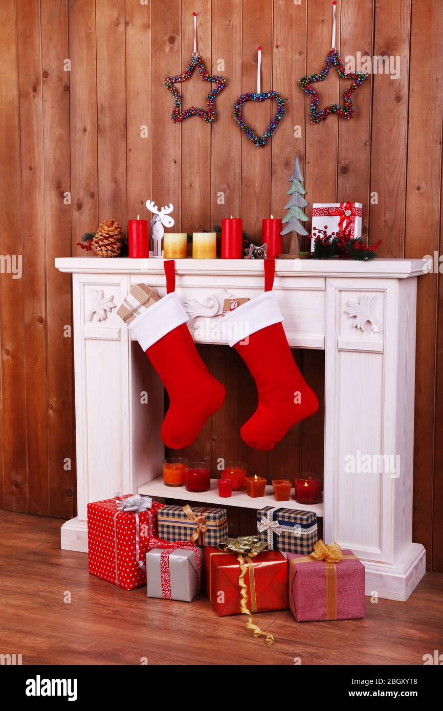 Christmas socks hanging on fireplace in room Stock Photo - Alamy