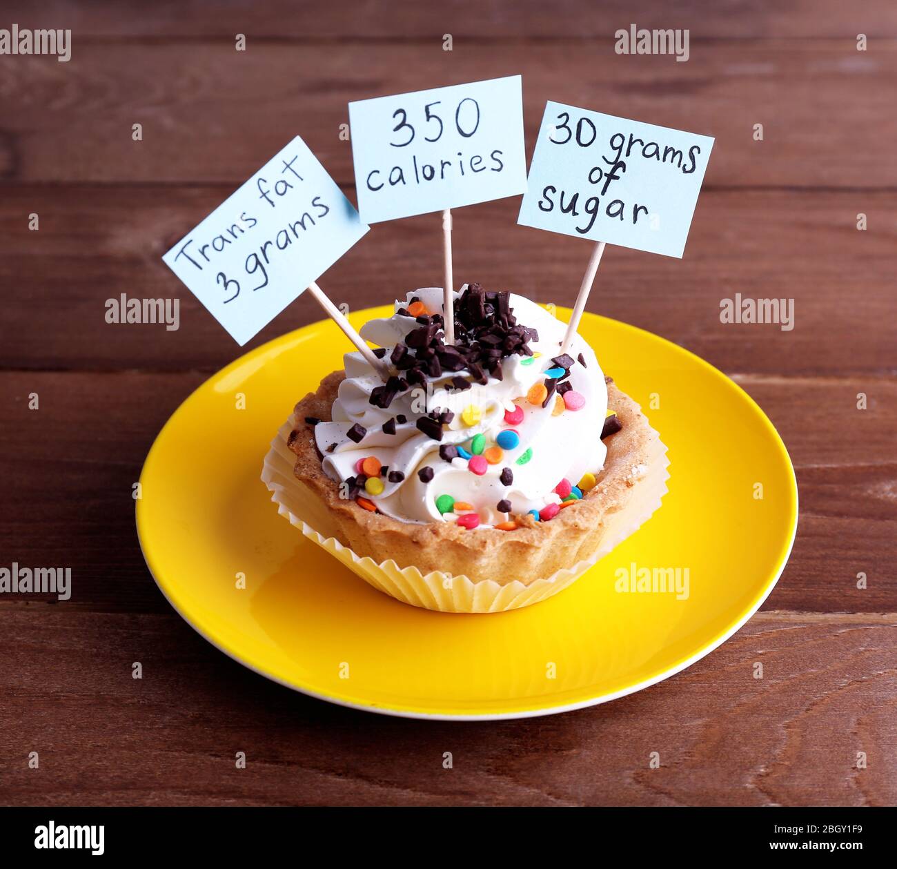 Delicious cake with calories count labels on color plate on wooden ...