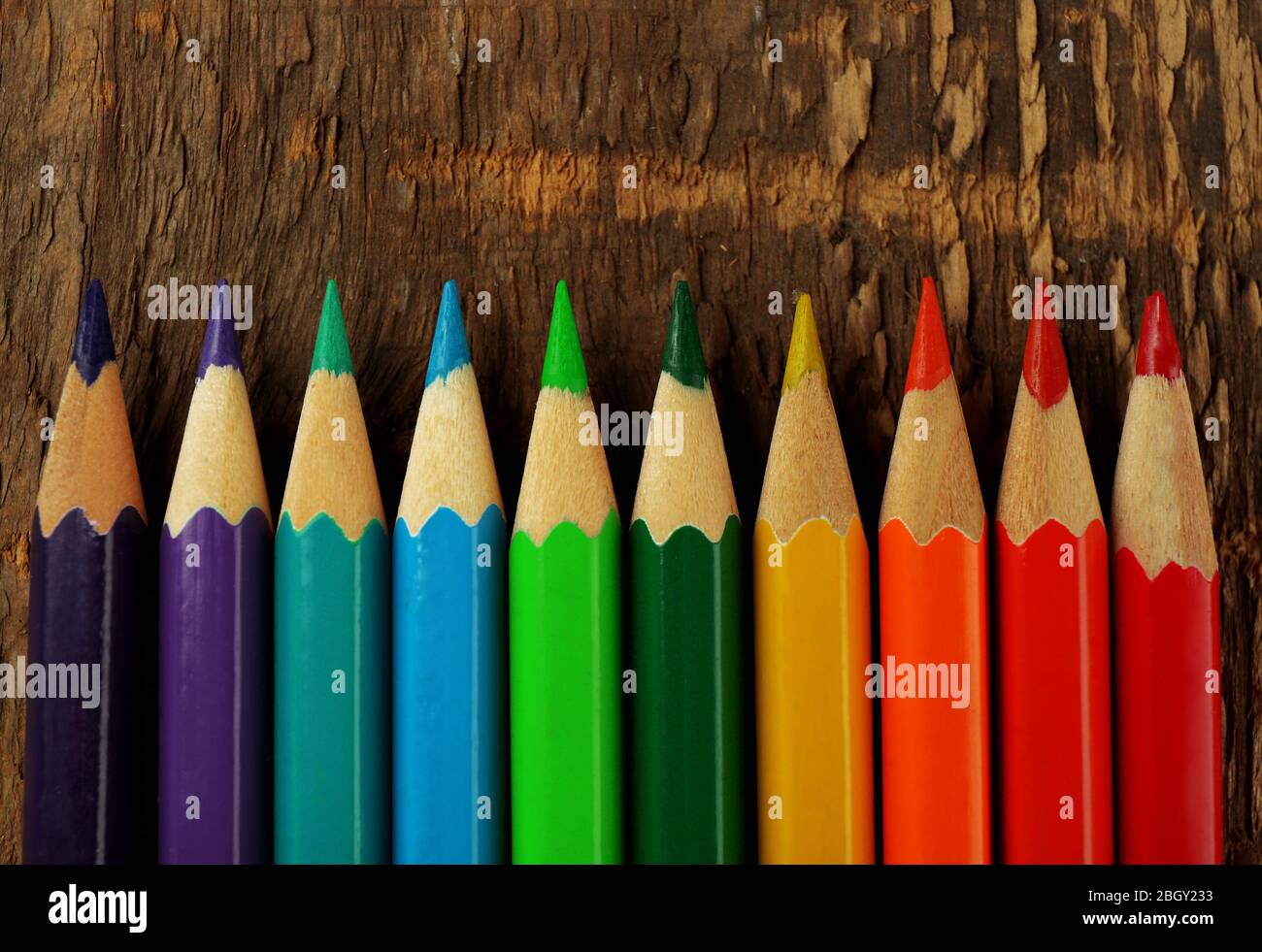 Colorful pencils on rustic wooden background Stock Photo - Alamy