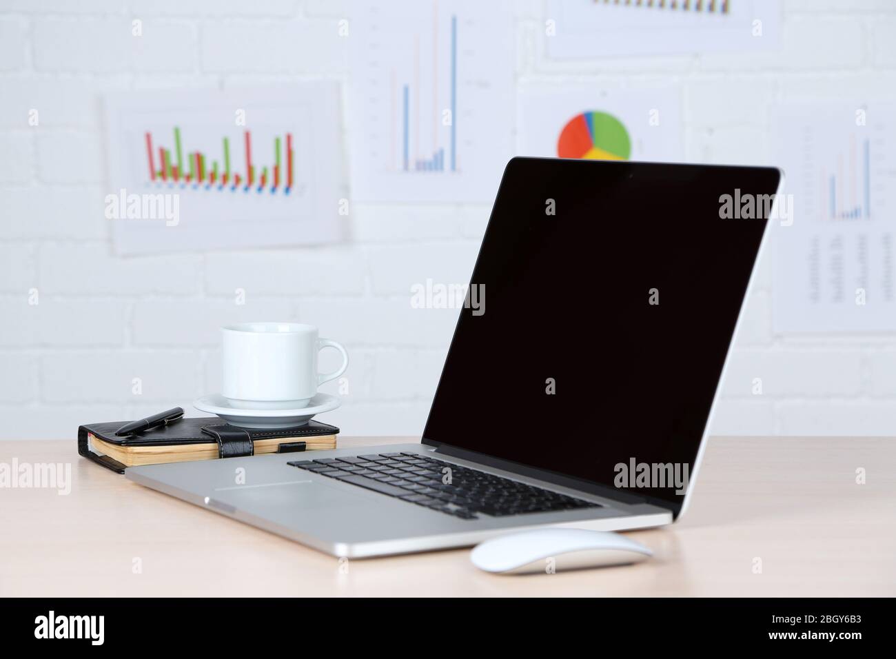 Modern laptop on table, on white wall background Stock Photo - Alamy