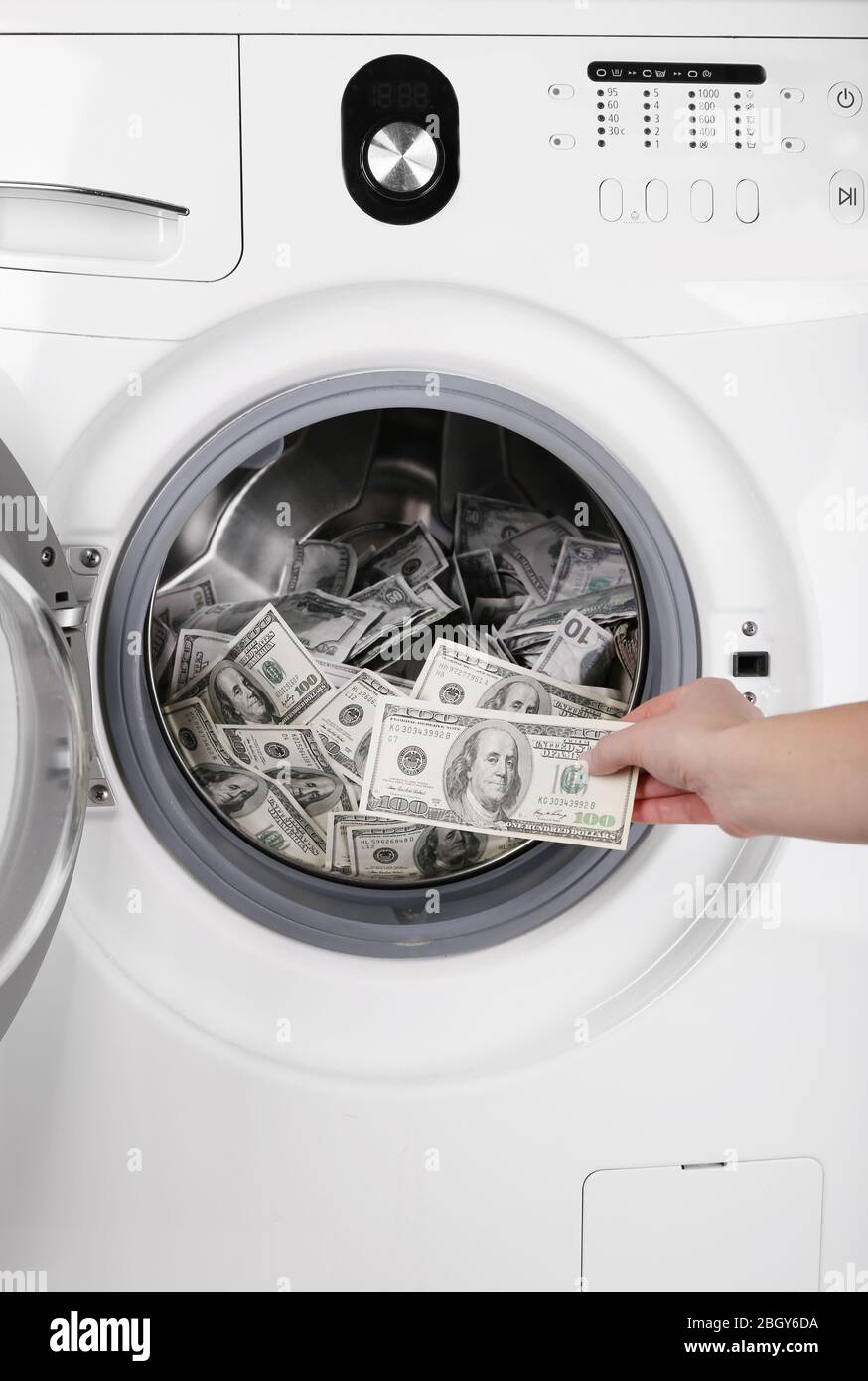 Female putting money into washing machine, closeup Stock Photo - Alamy