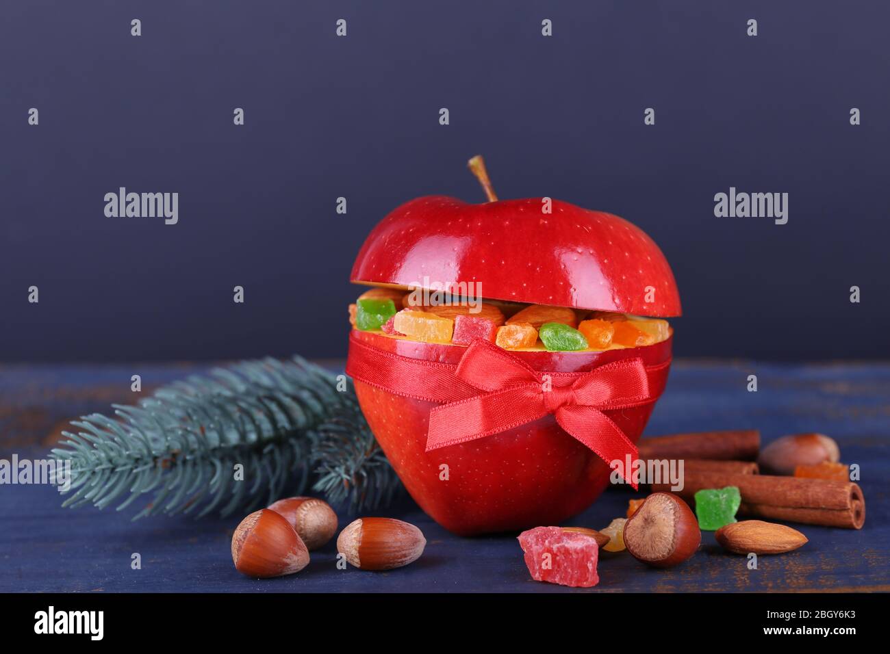 Red apple stuffed with dried fruits with cinnamon, sprig of fir tree ...