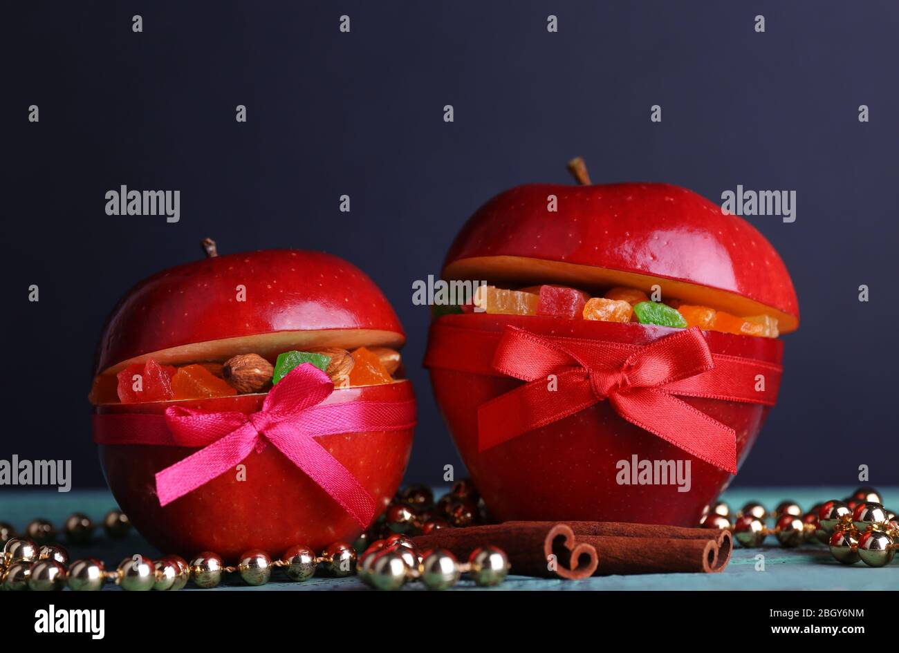 Christmas red apples stuffed with dried fruits on color wooden table ...