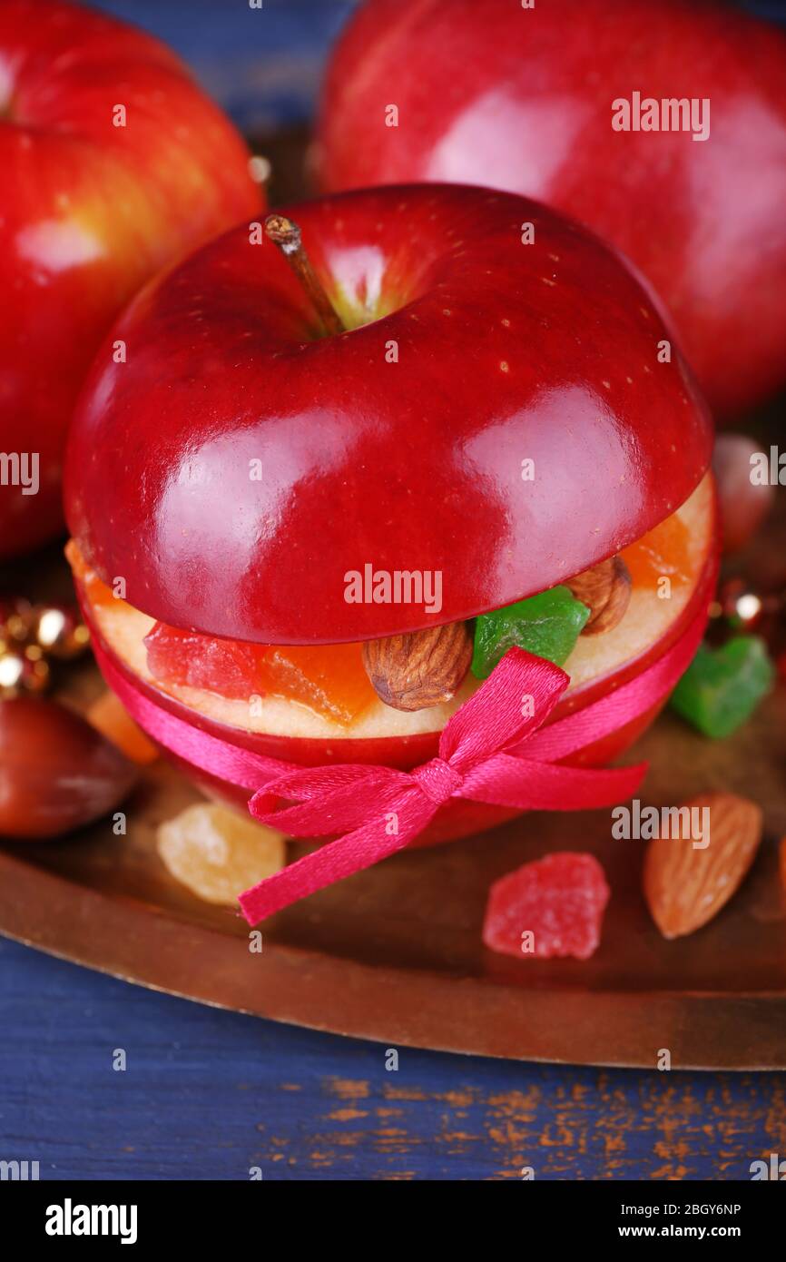 Christmas red apples stuffed with dried fruits on metal tray on color ...