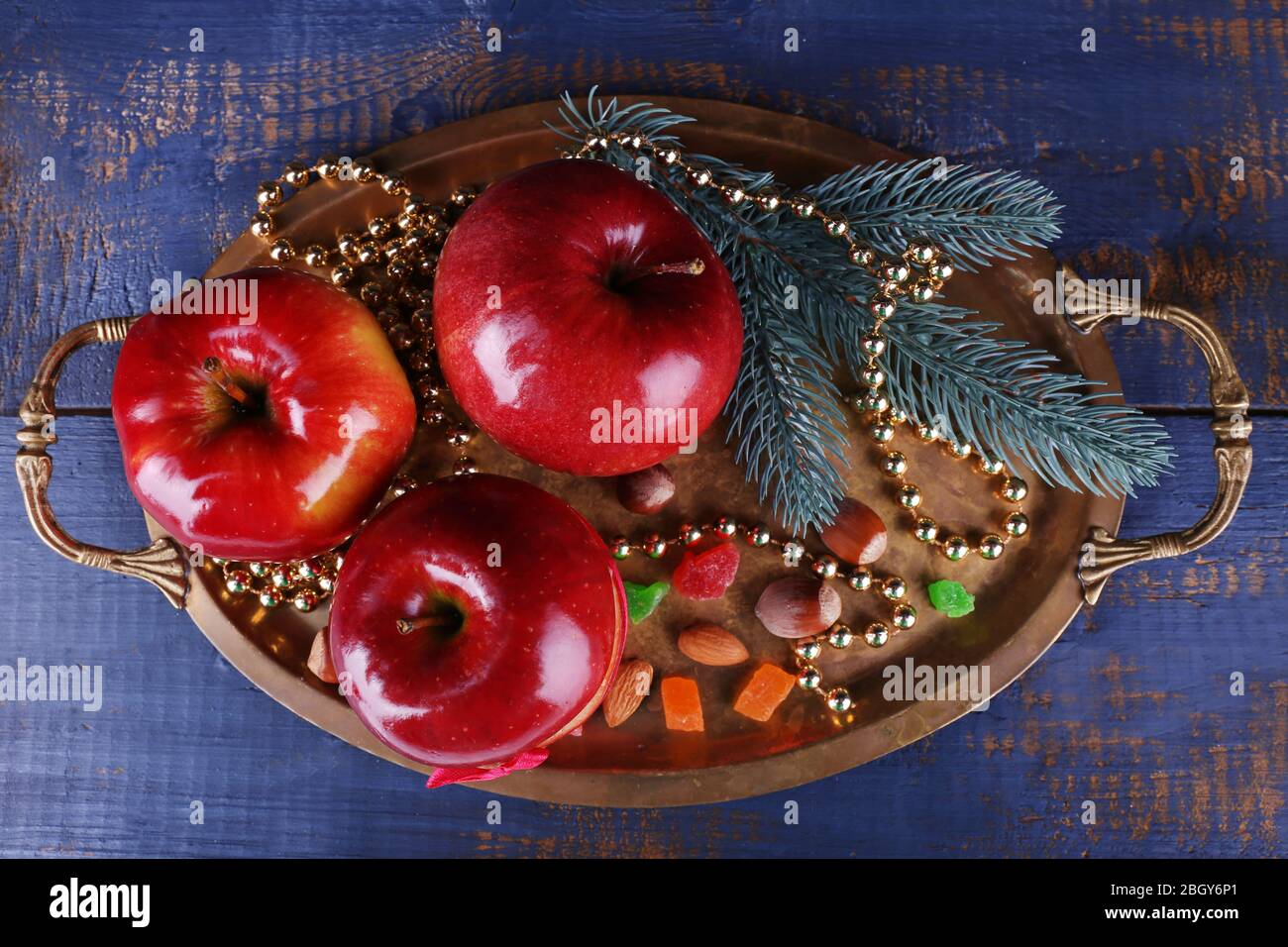 Christmas red apples stuffed with dried fruits on metal tray on color ...