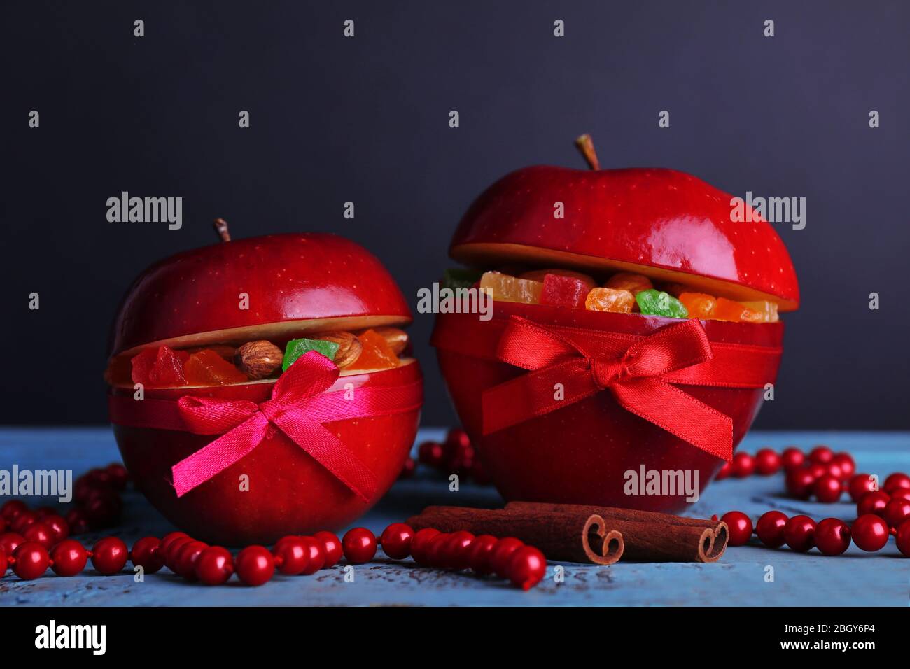 Christmas red apples stuffed with dried fruits on color wooden table ...