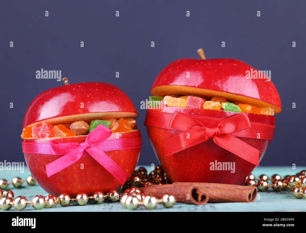 Christmas red apples stuffed with dried fruits on color wooden table ...