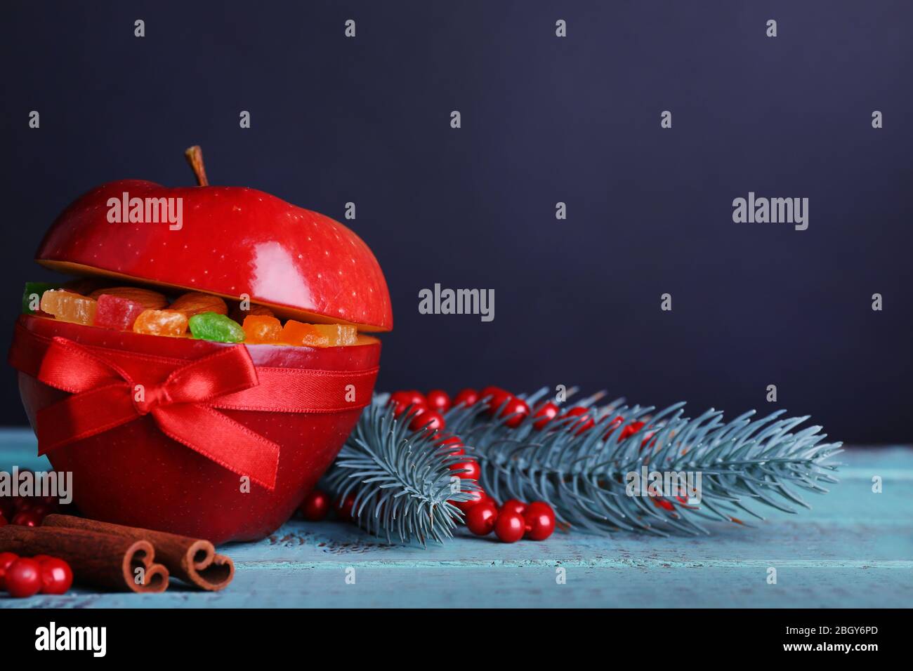 Christmas red apple stuffed with dried fruits on color wooden table and ...