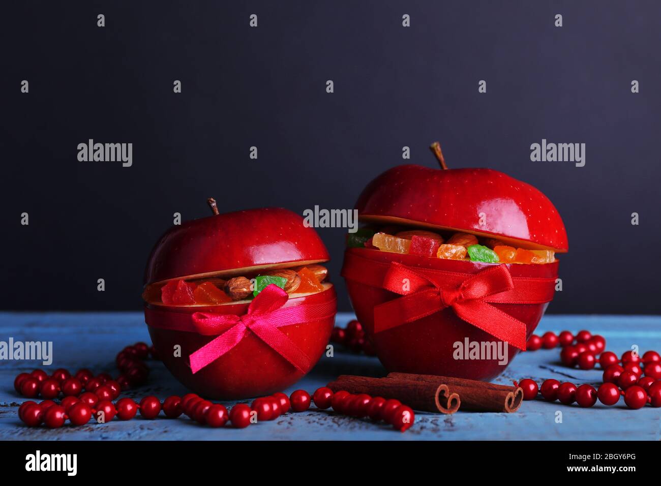 Christmas red apples stuffed with dried fruits on color wooden table ...