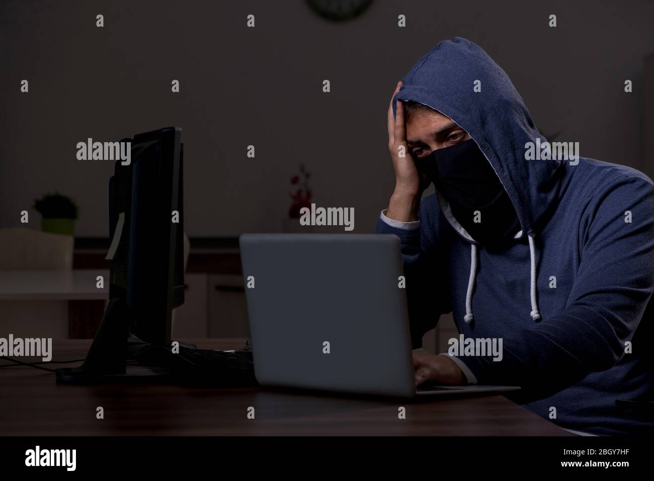 Male hacker hacking security firewall late in the office Stock Photo ...
