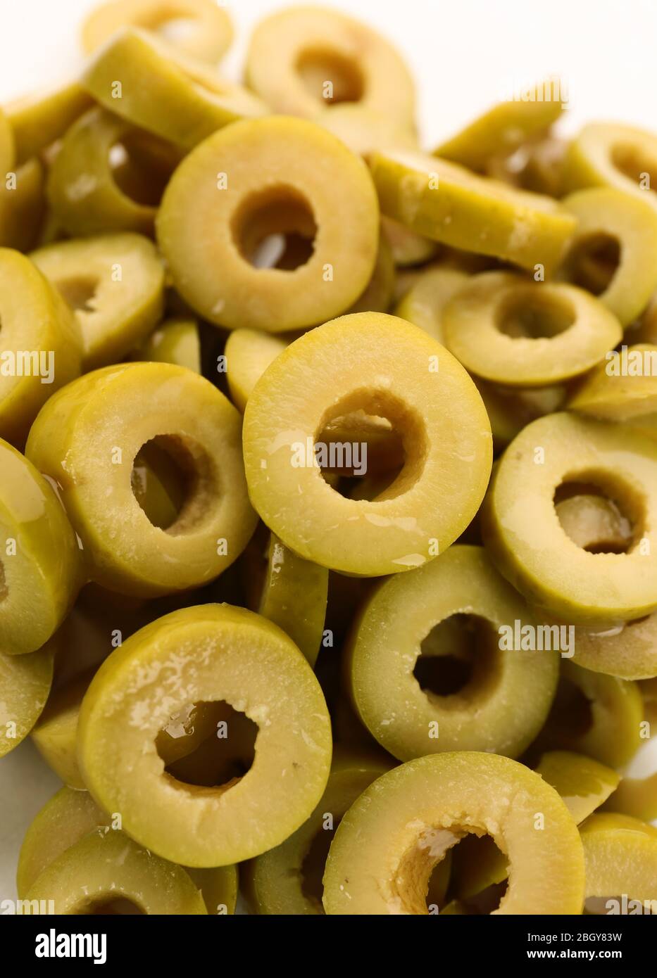 Green cut olive rings on white background Stock Photo - Alamy
