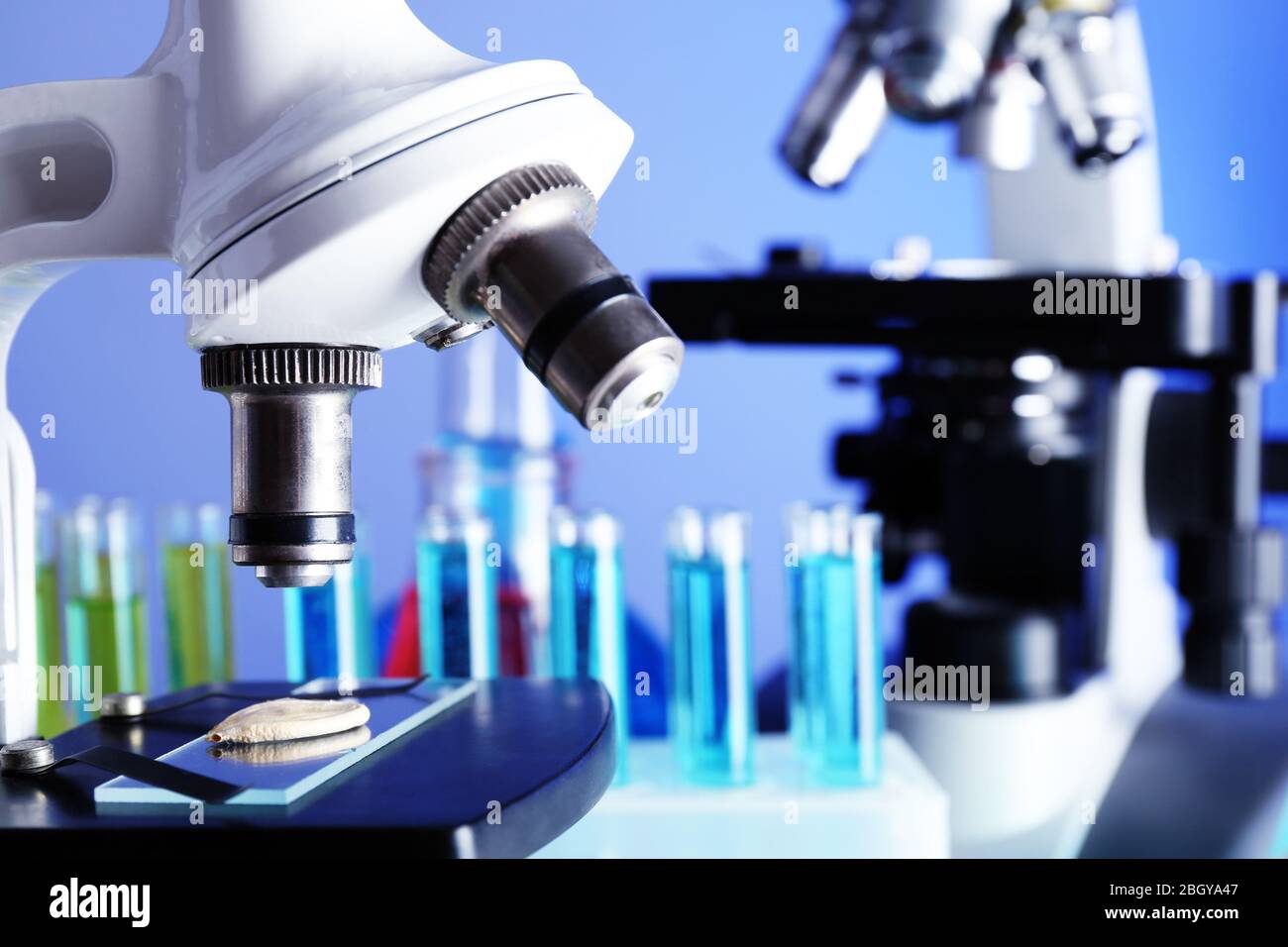 Microscopes and test tubes on table, on color background Stock Photo ...
