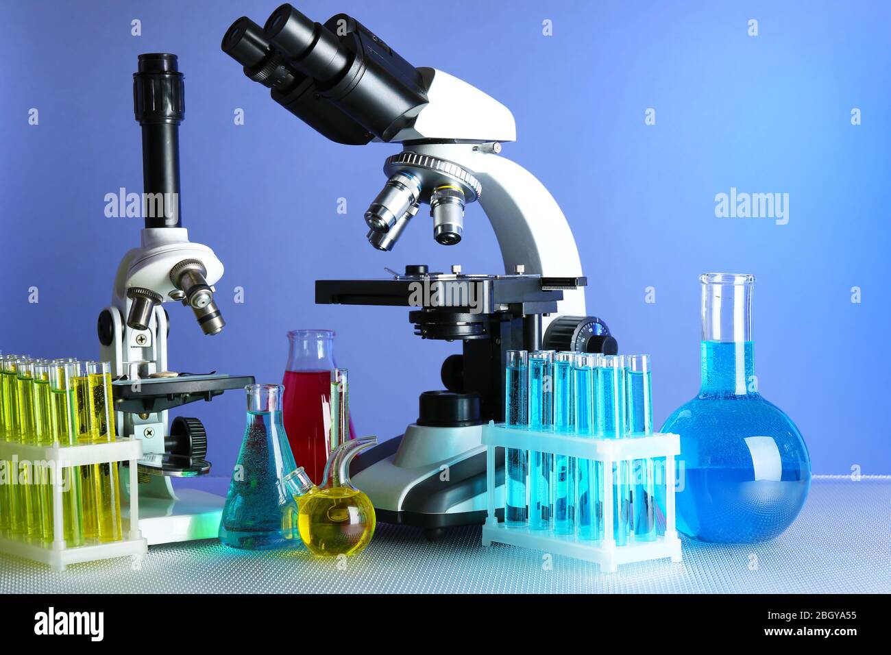 Microscopes and test tubes on table, on color background Stock Photo ...