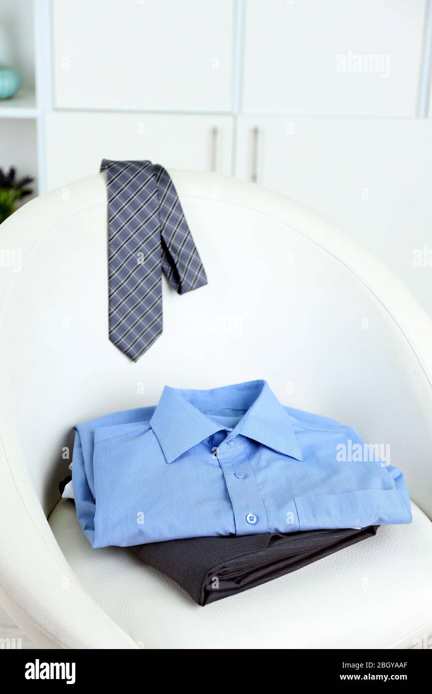 Men's clothes on chair with shelf on background Stock Photo - Alamy