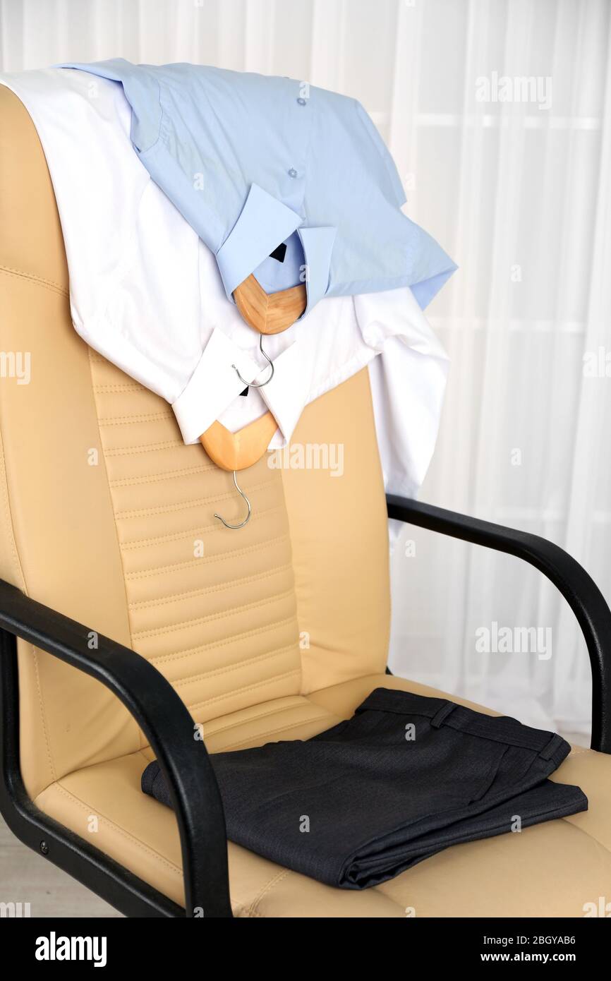 Men's clothes on chair with curtain on background Stock Photo - Alamy