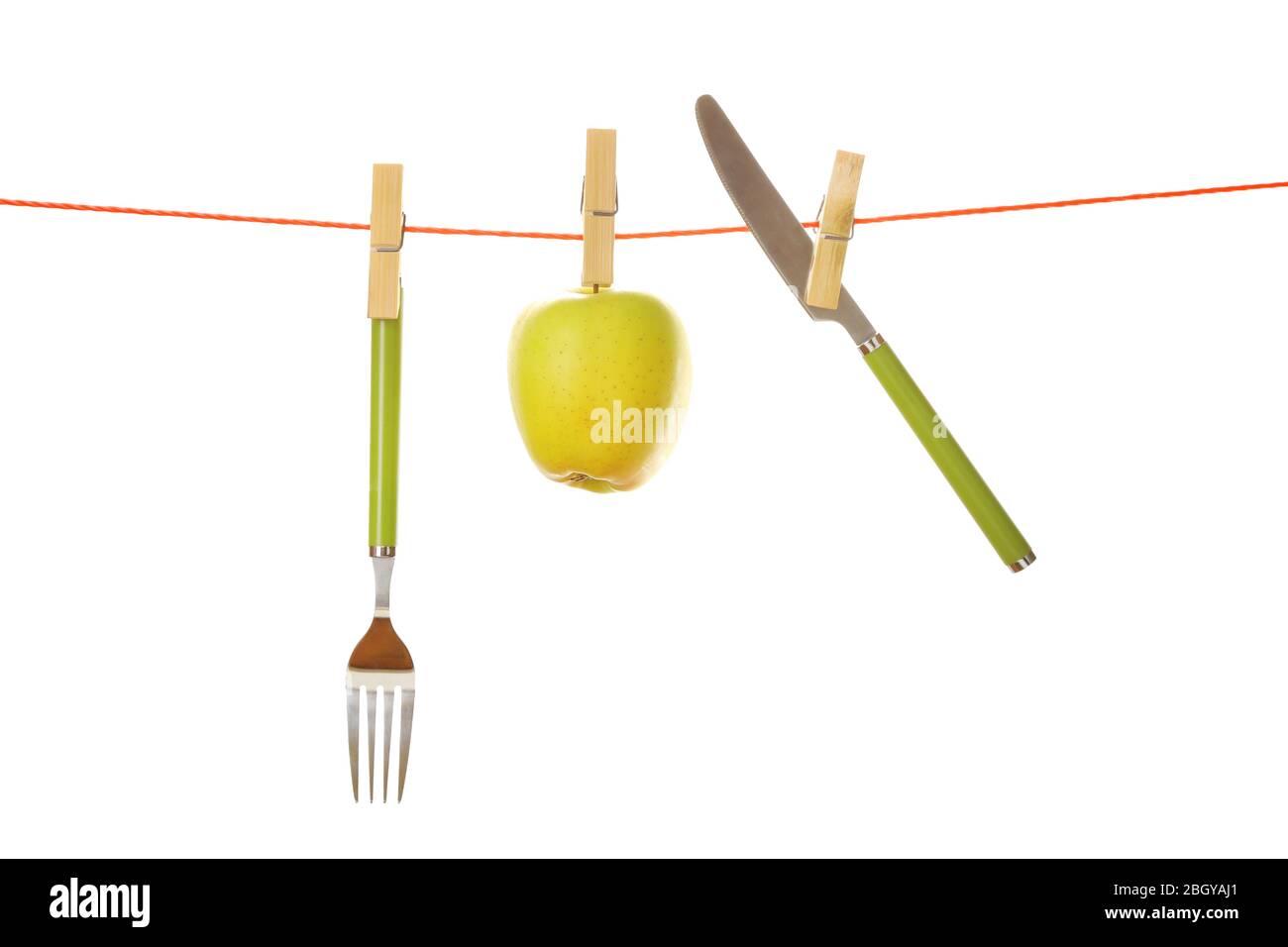 Fork, knife and apple hanging from clothesline isolated on white ...