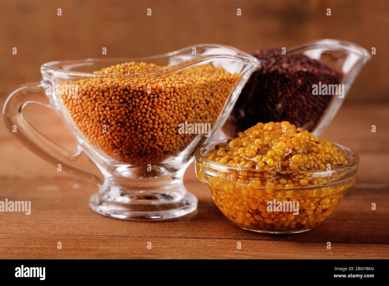 Composition of different kinds of mustard on color wooden background ...