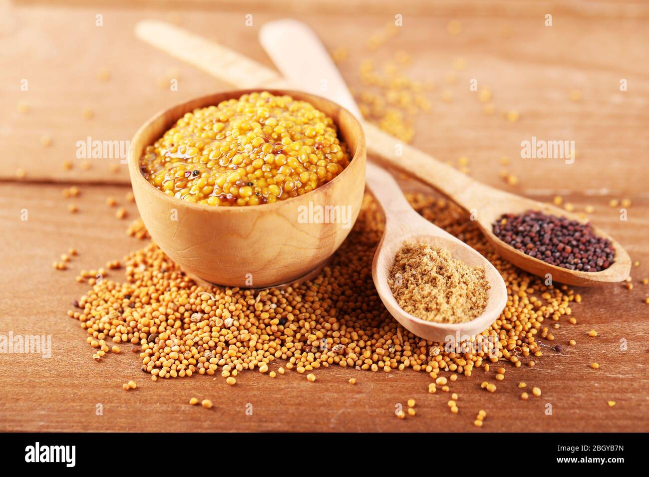 Composition of different kinds of mustard on wooden background Stock ...