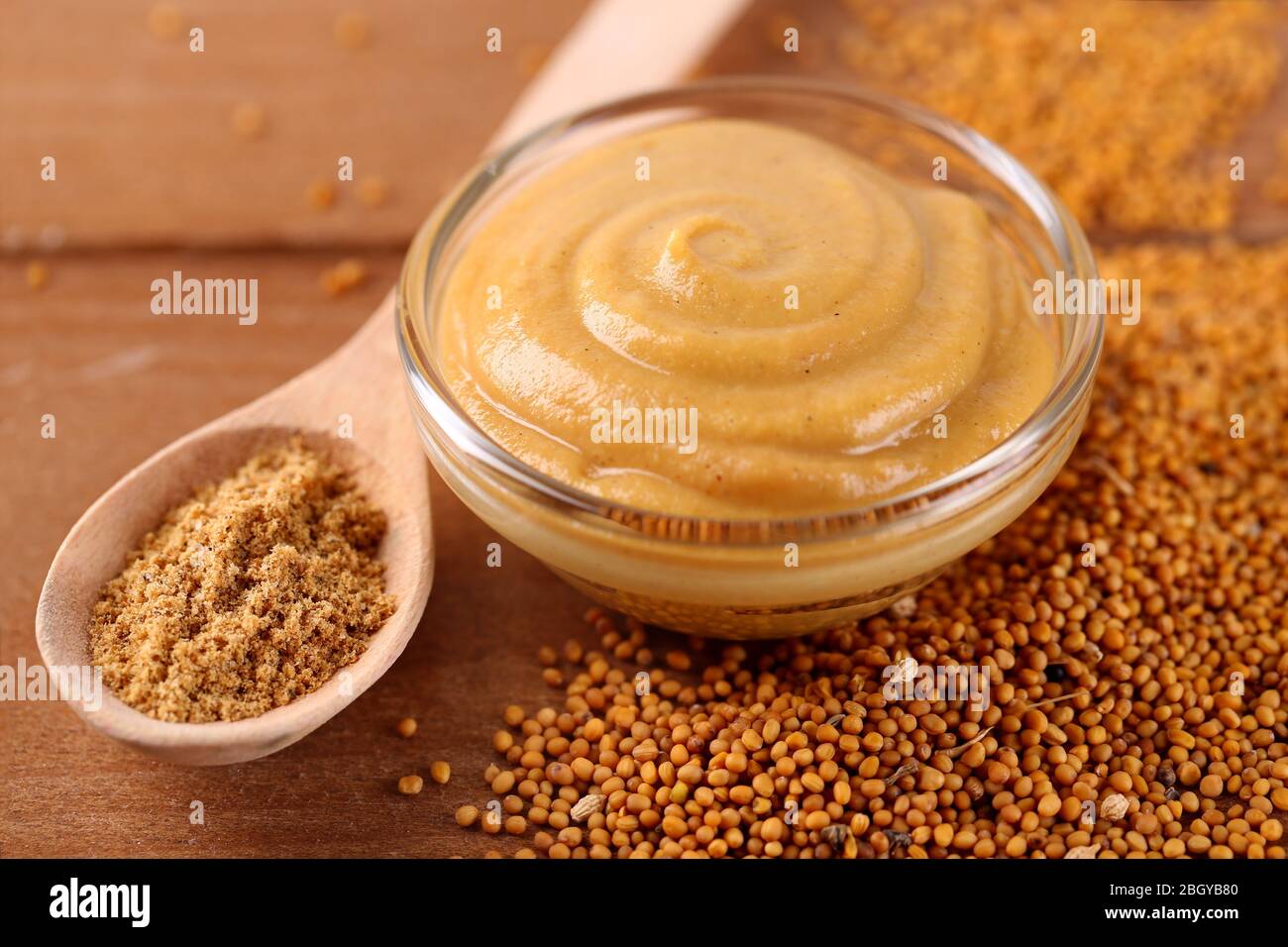 Composition of different kinds of mustard on wooden background Stock ...