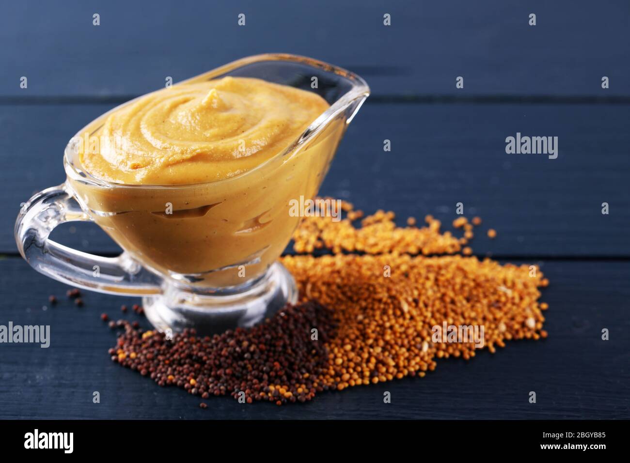 Composition of different kinds of mustard on color wooden background ...