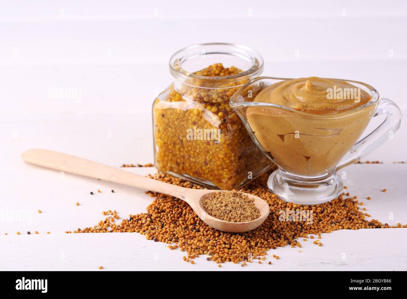 Composition of different kinds of mustard on color wooden background ...