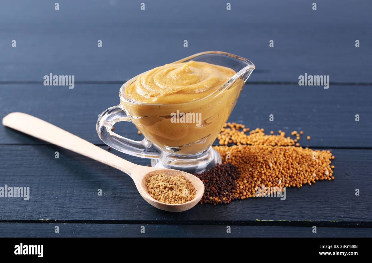 Composition of different kinds of mustard on color wooden background ...