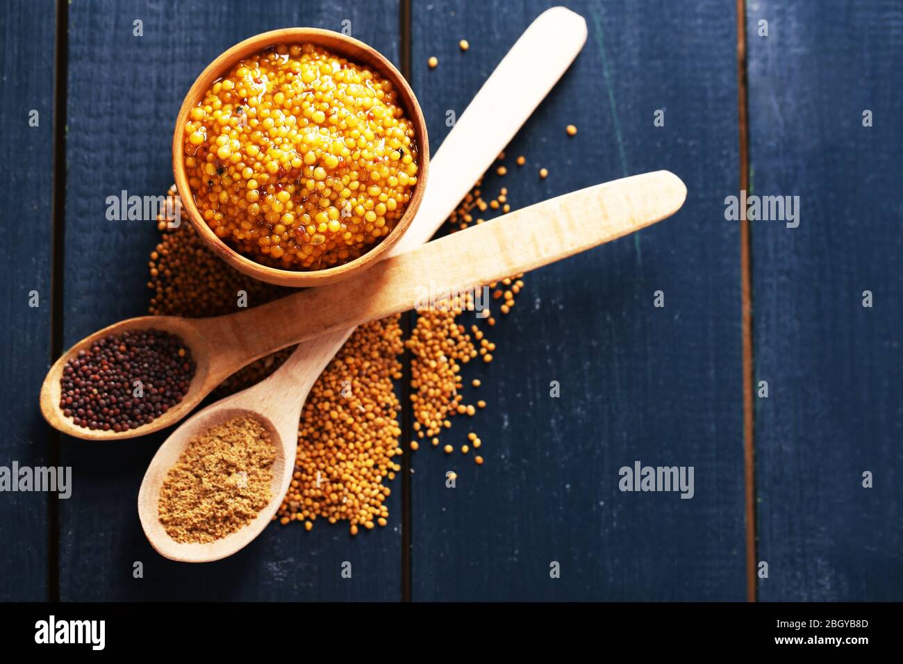 Composition of different kinds of mustard on color wooden background ...