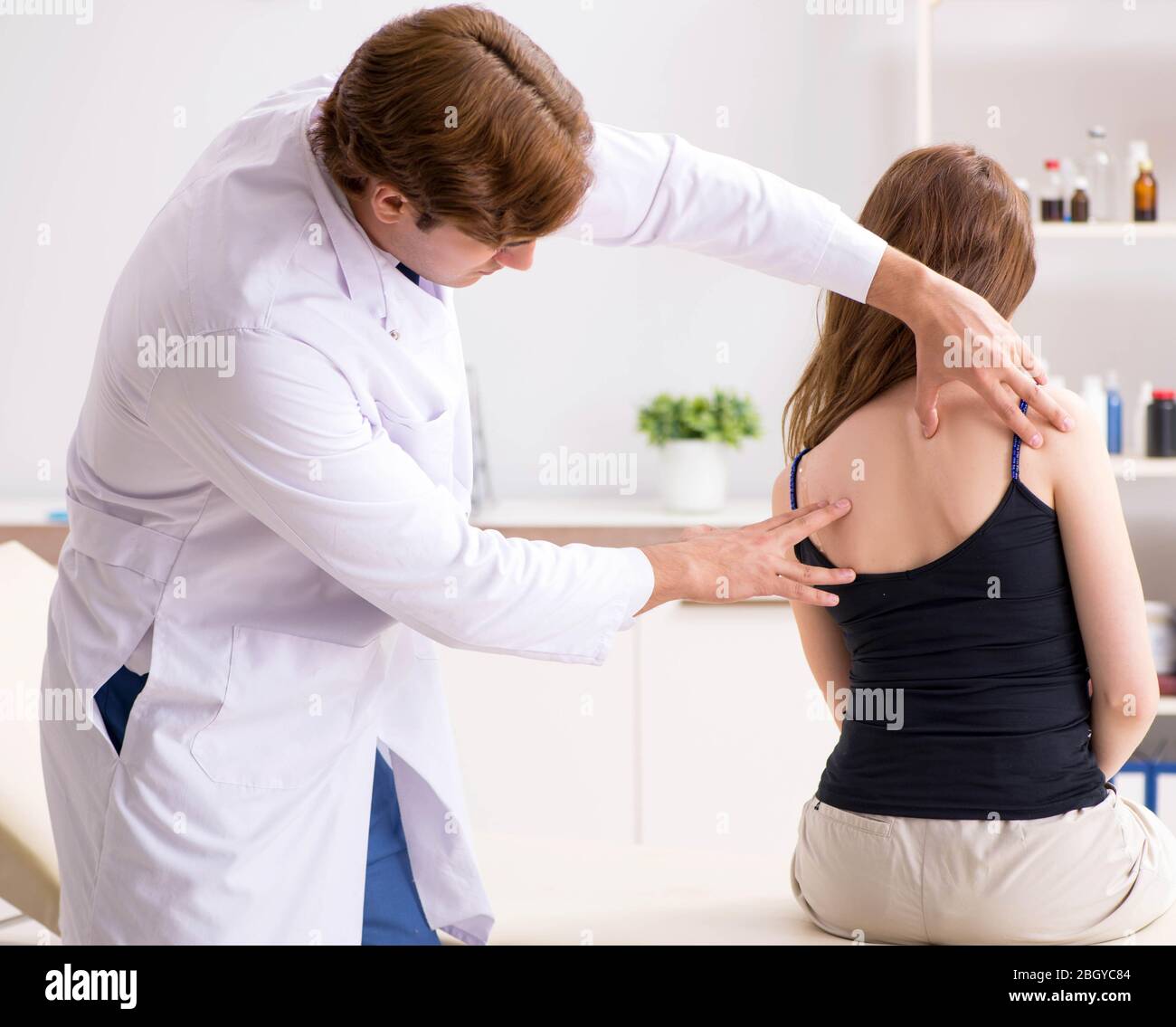 The female patient visiting young handsome doctor chiropractor Stock ...