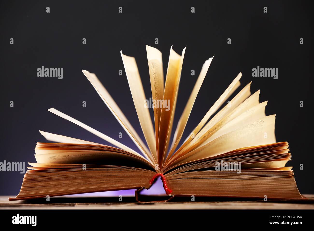 Open book over dark colorful background Stock Photo - Alamy