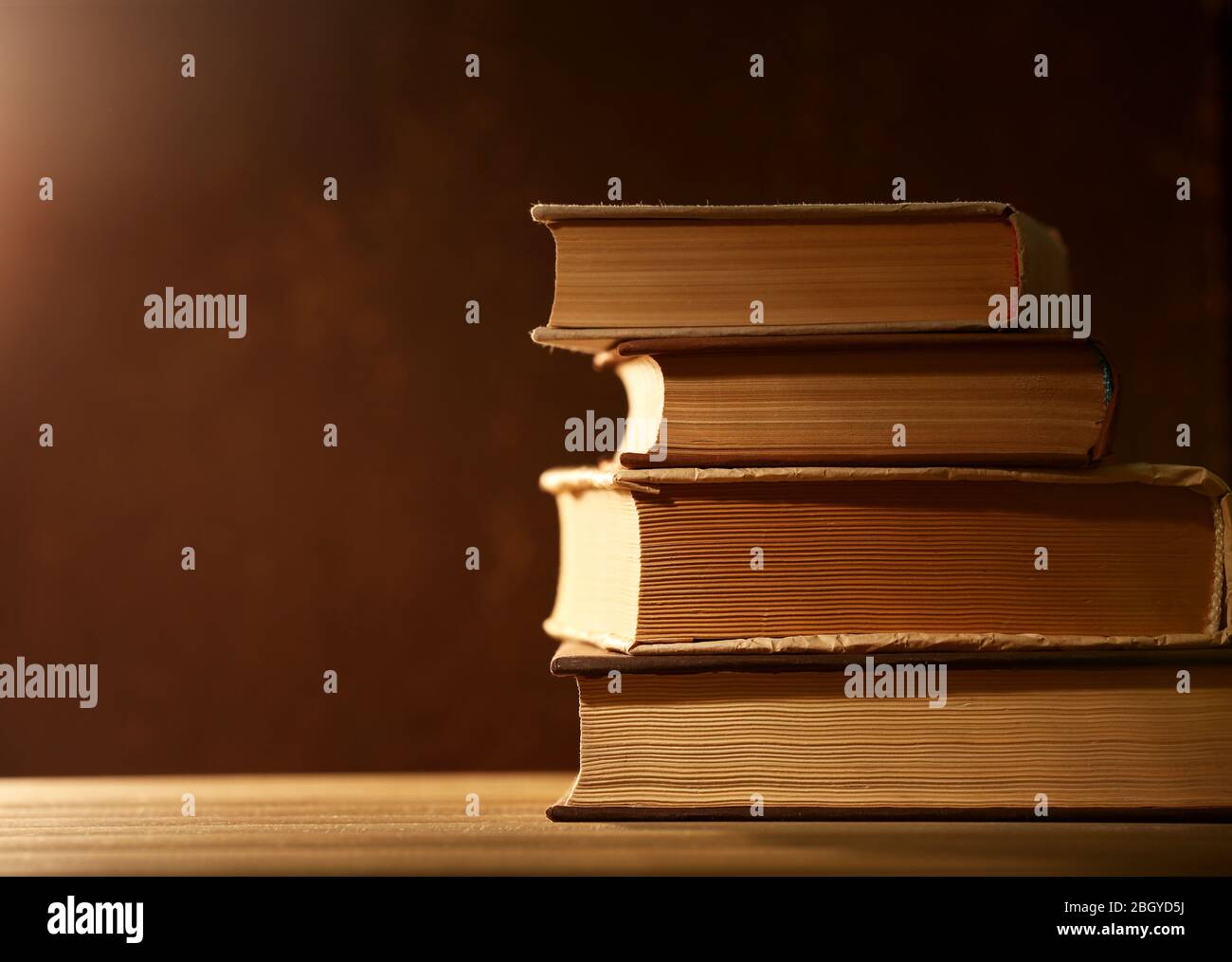 Books with light over dark background Stock Photo - Alamy