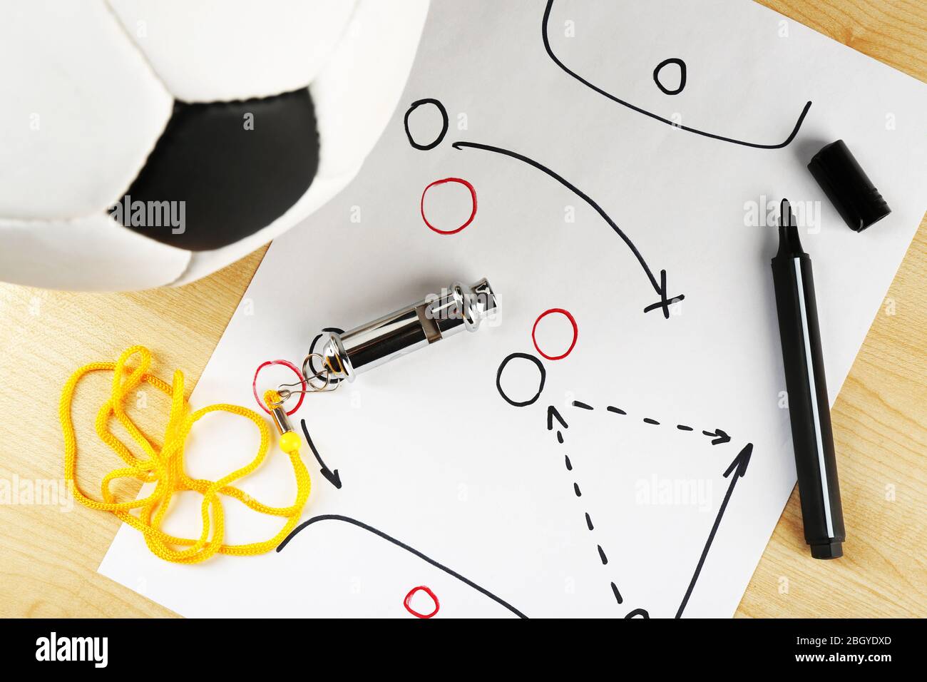 Scheme football game on sheet of paper and wooden table background ...