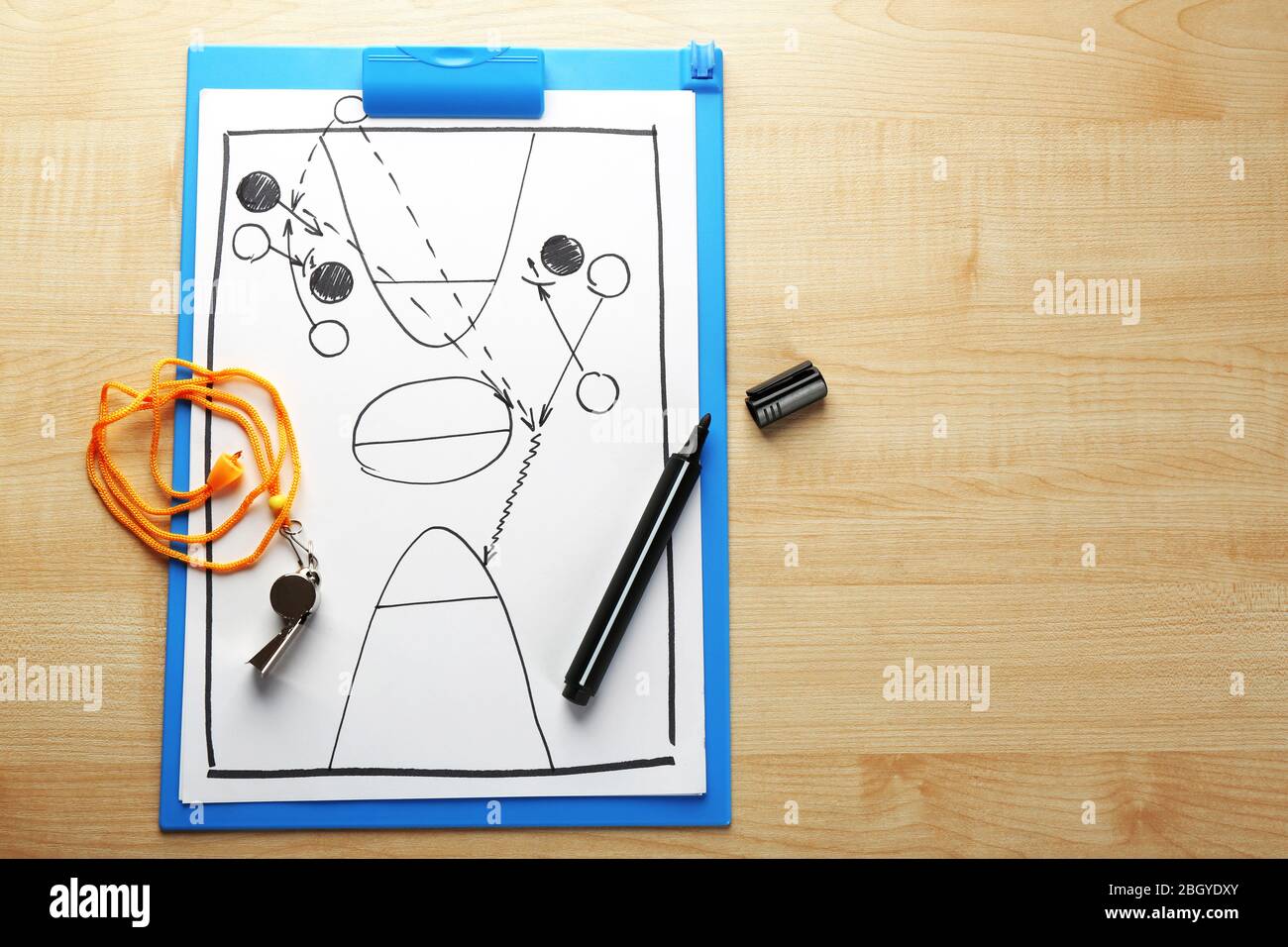 Scheme basketball game on clip board paper with marker and wooden table ...