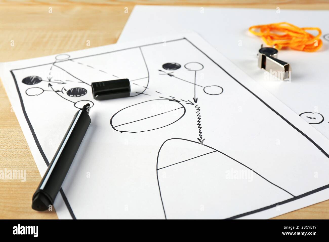 Scheme basketball game on sheet of paper and wooden table background ...