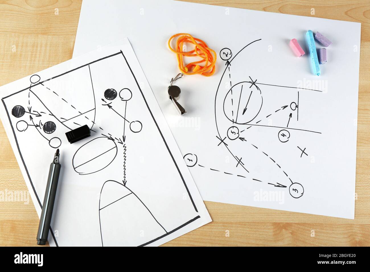 Scheme basketball game on sheet of paper and wooden table background ...