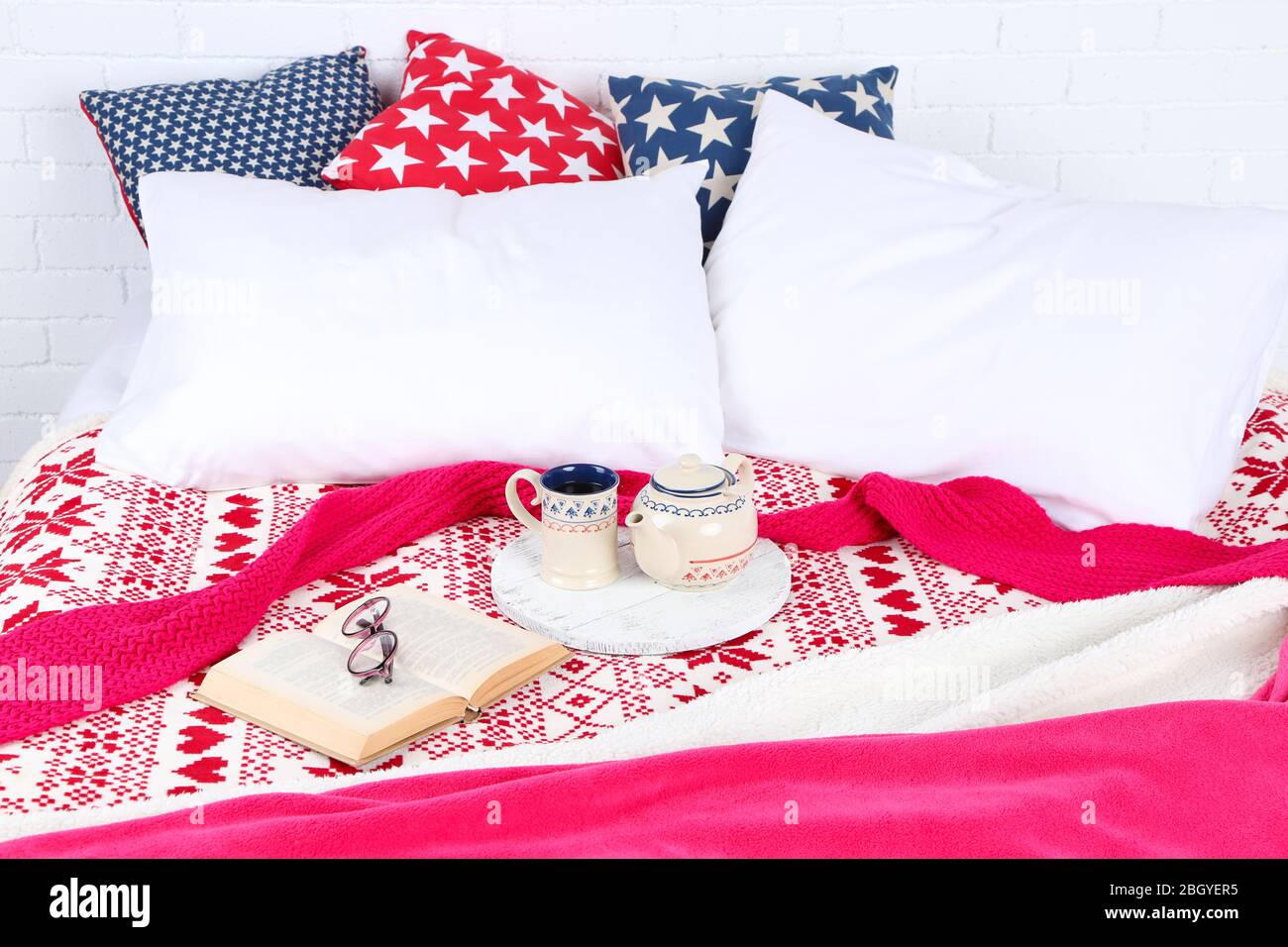 Book and tea on bed close-up Stock Photo - Alamy