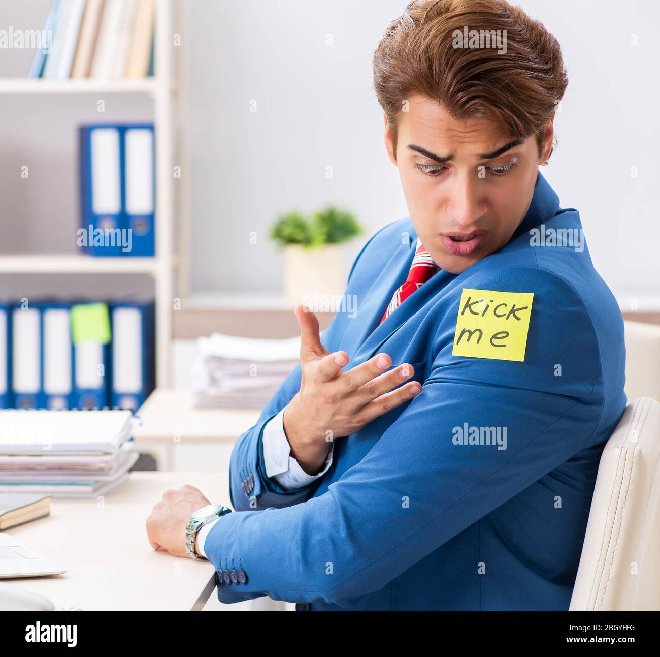 The office prank with kick me message on sticky note Stock Photo - Alamy