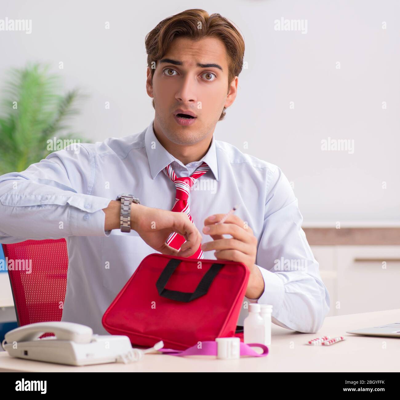 The man with first aid kit in the office Stock Photo - Alamy