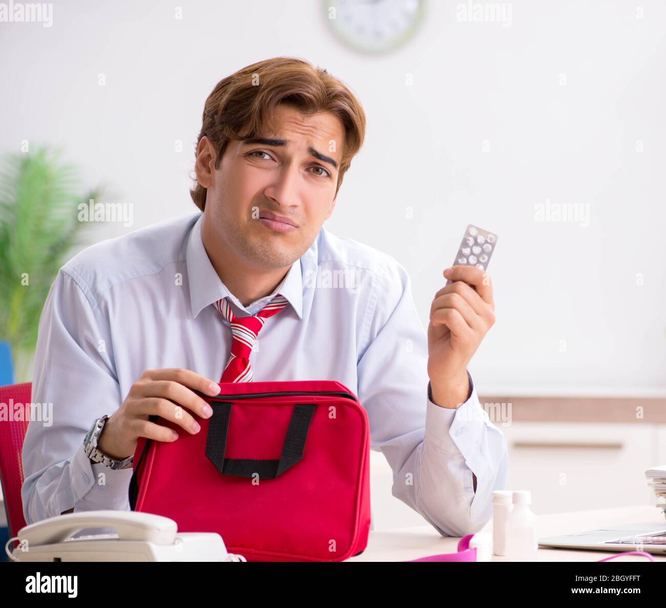 The man with first aid kit in the office Stock Photo - Alamy